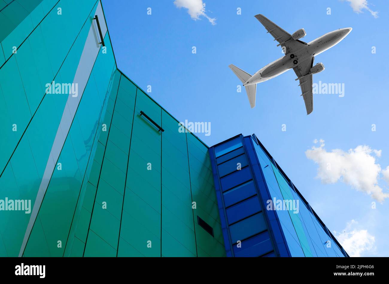 Airplane in the sky with modern buildings Stock Photo - Alamy