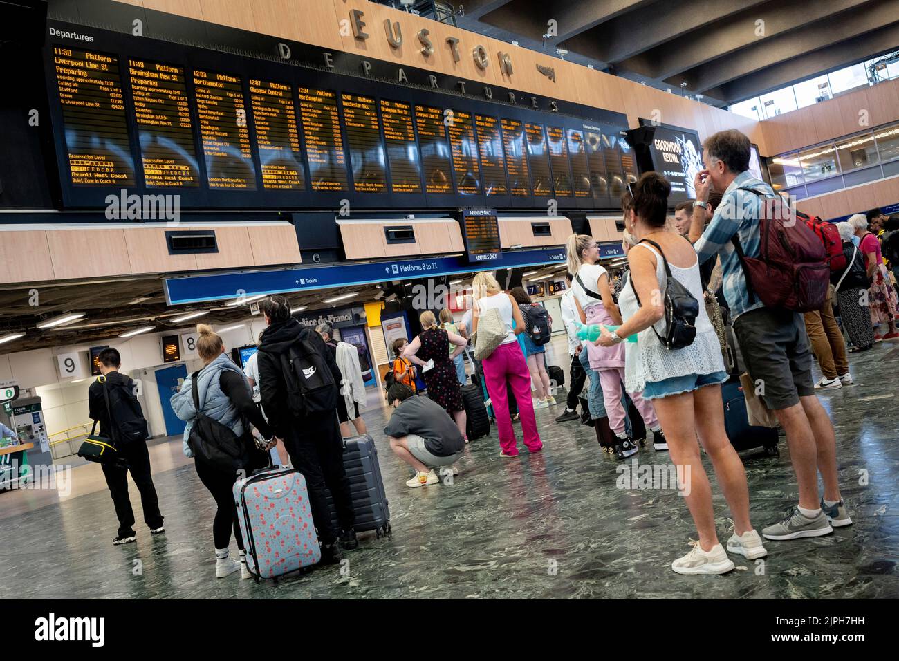 Hopeful passengers look at the Departures board at Euston Station ...