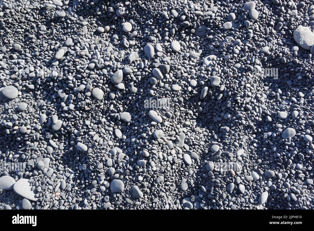 Black sand and pebbles - top view Stock Photo - Alamy
