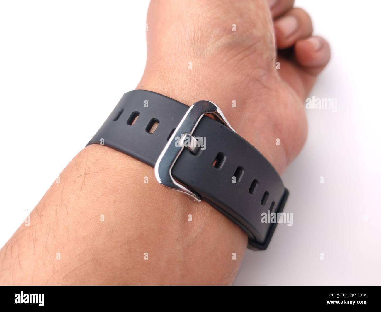 A closeup shot of an arm with a watch that has a black rubber band a ...