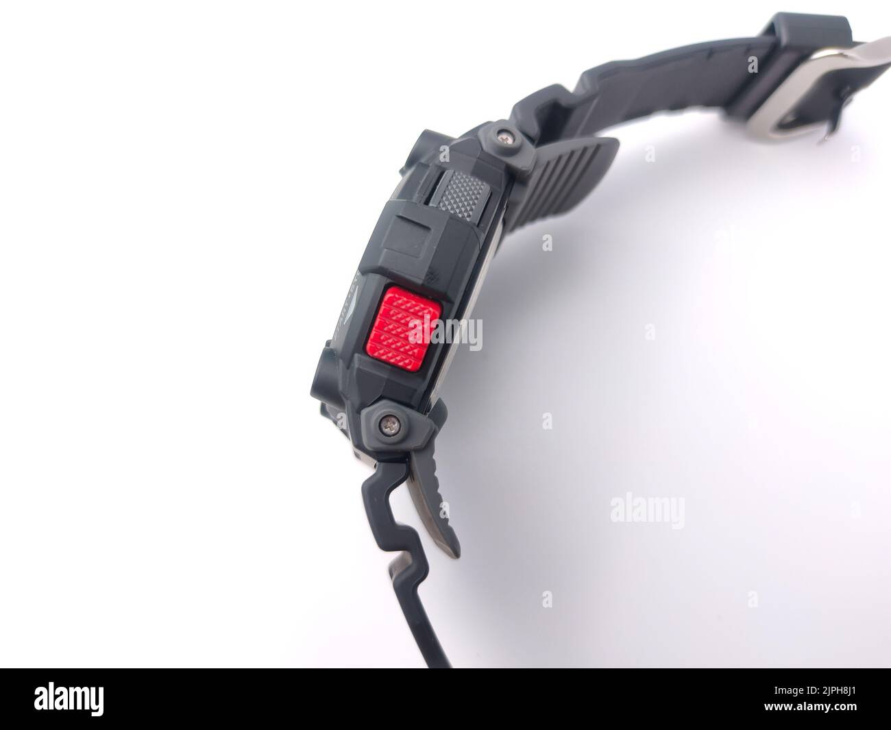 A top view of the side of a black rubber sport watch on a white surface ...