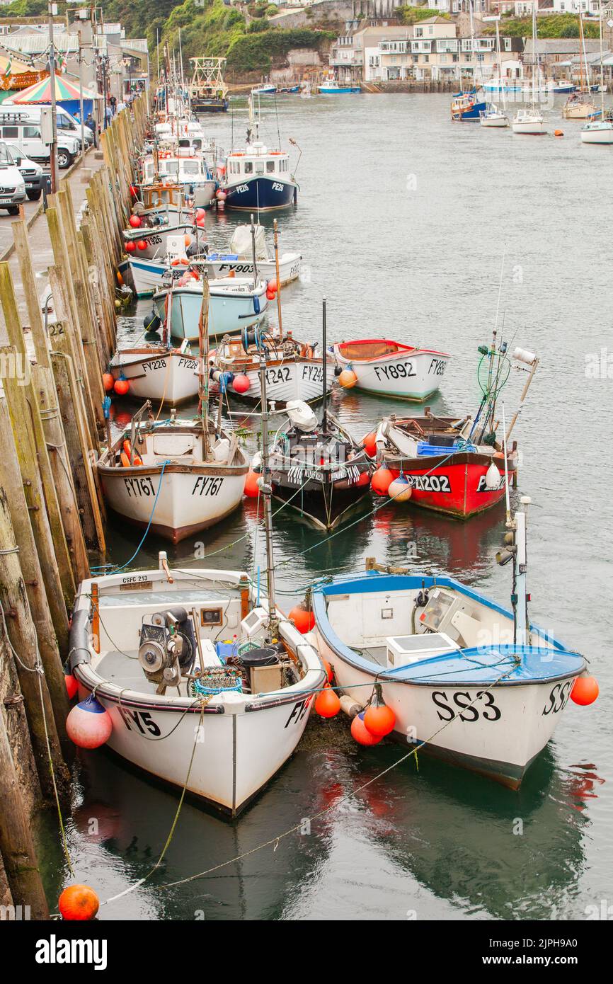 Rows of fishing boats tied together along the quay at Looe town harbour ...