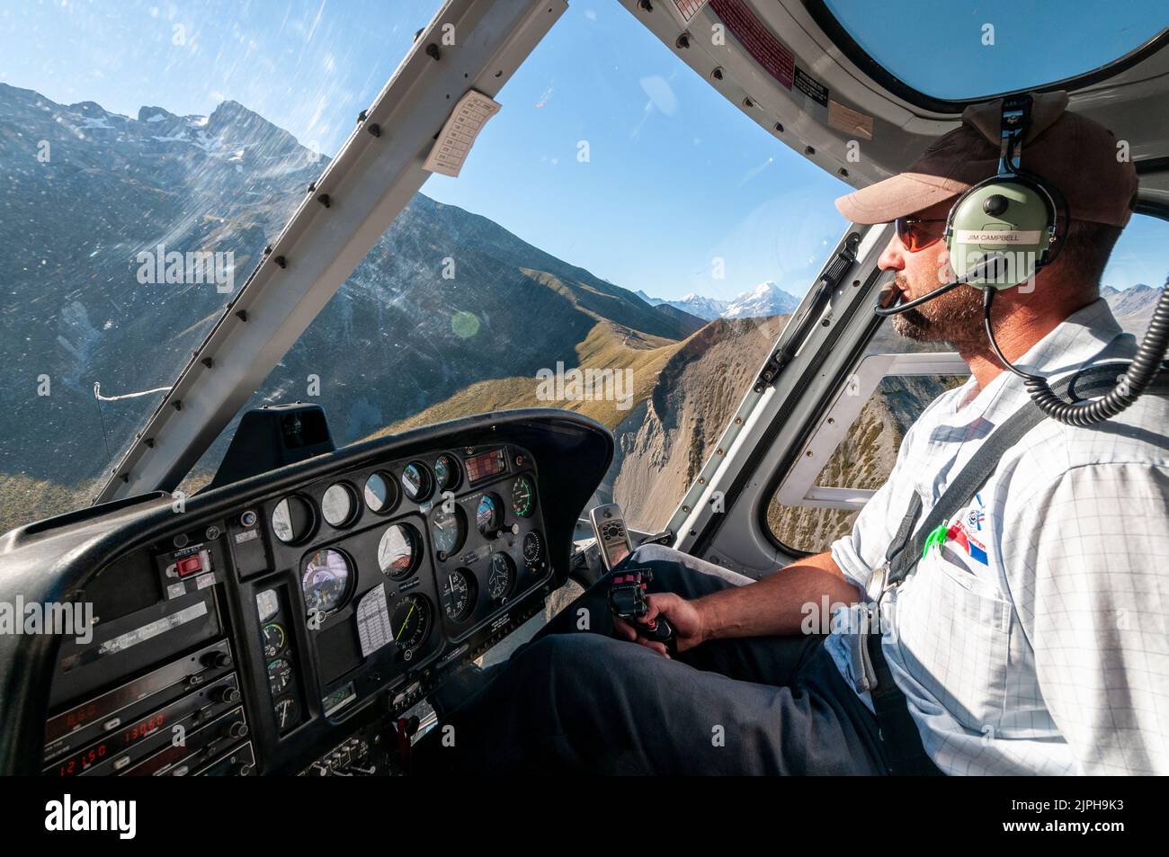 A helicopter pilot at the controls of his tourist sight-seeing ...