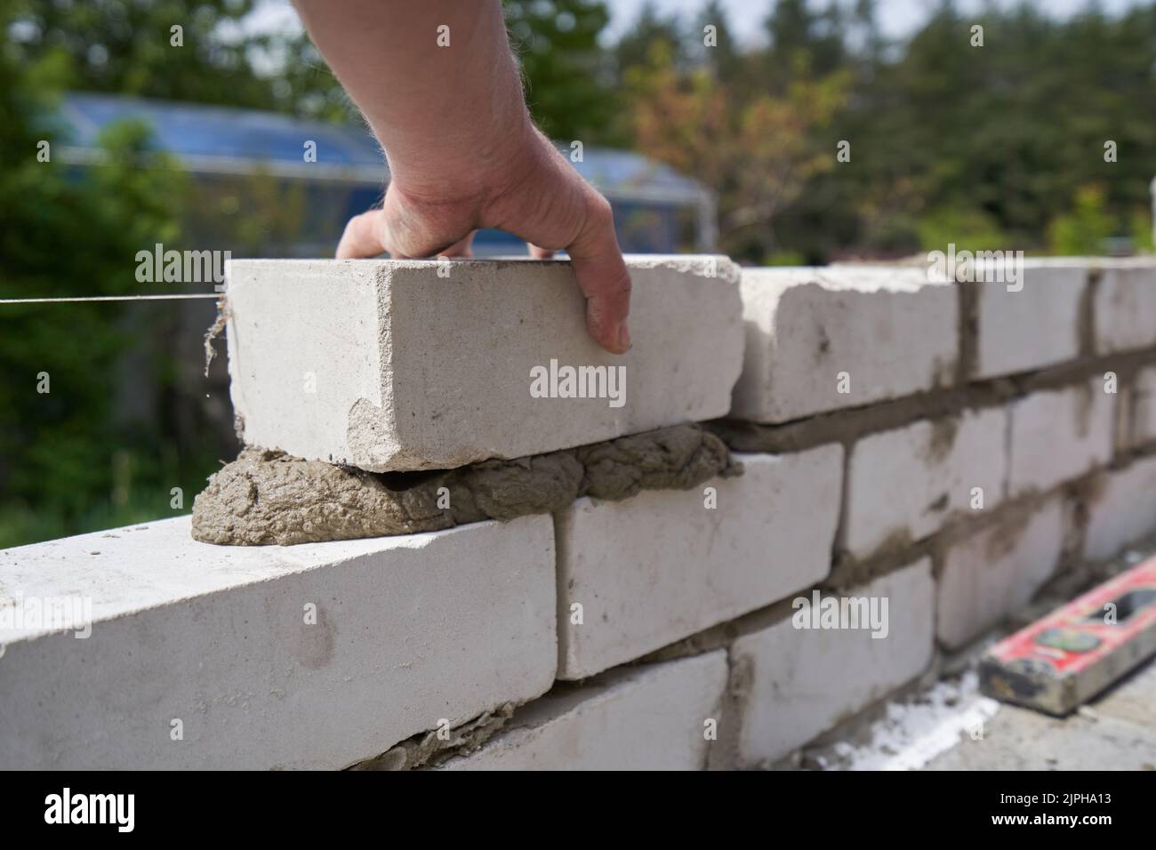 Builder bricklayer builds walls from bricks, close-up Stock Photo - Alamy
