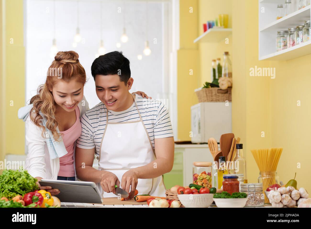 Beautiful smiling Asian couple cooking dinner together Stock Photo - Alamy