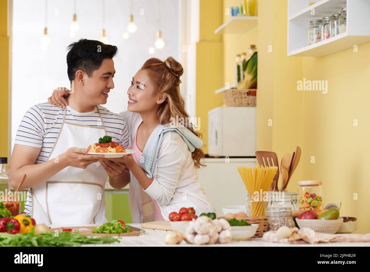 Happy young Asian couple enjoying making dinner together Stock Photo ...