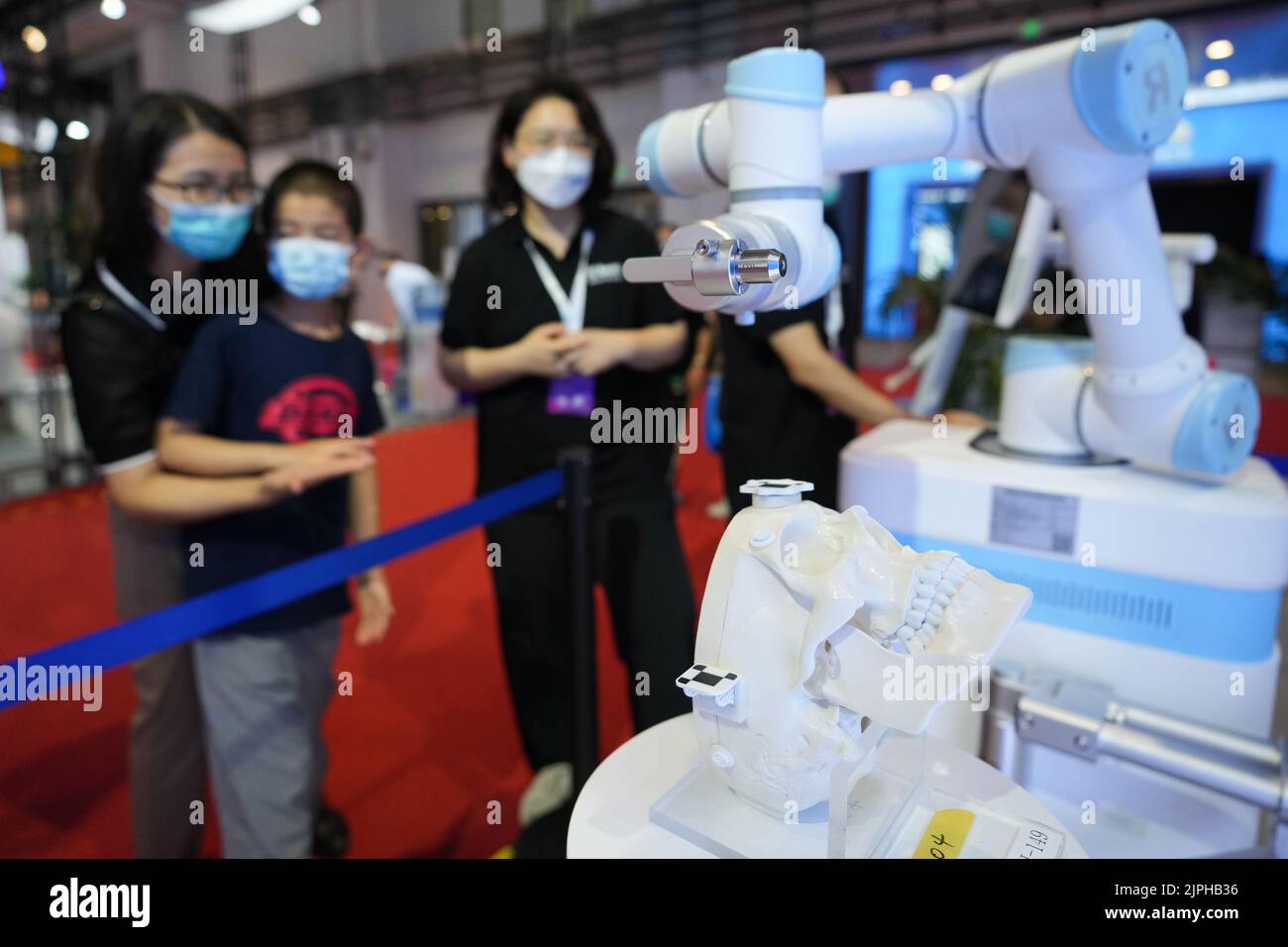 Beijing, China. 18th Aug, 2022. People look at a surgery robot during ...