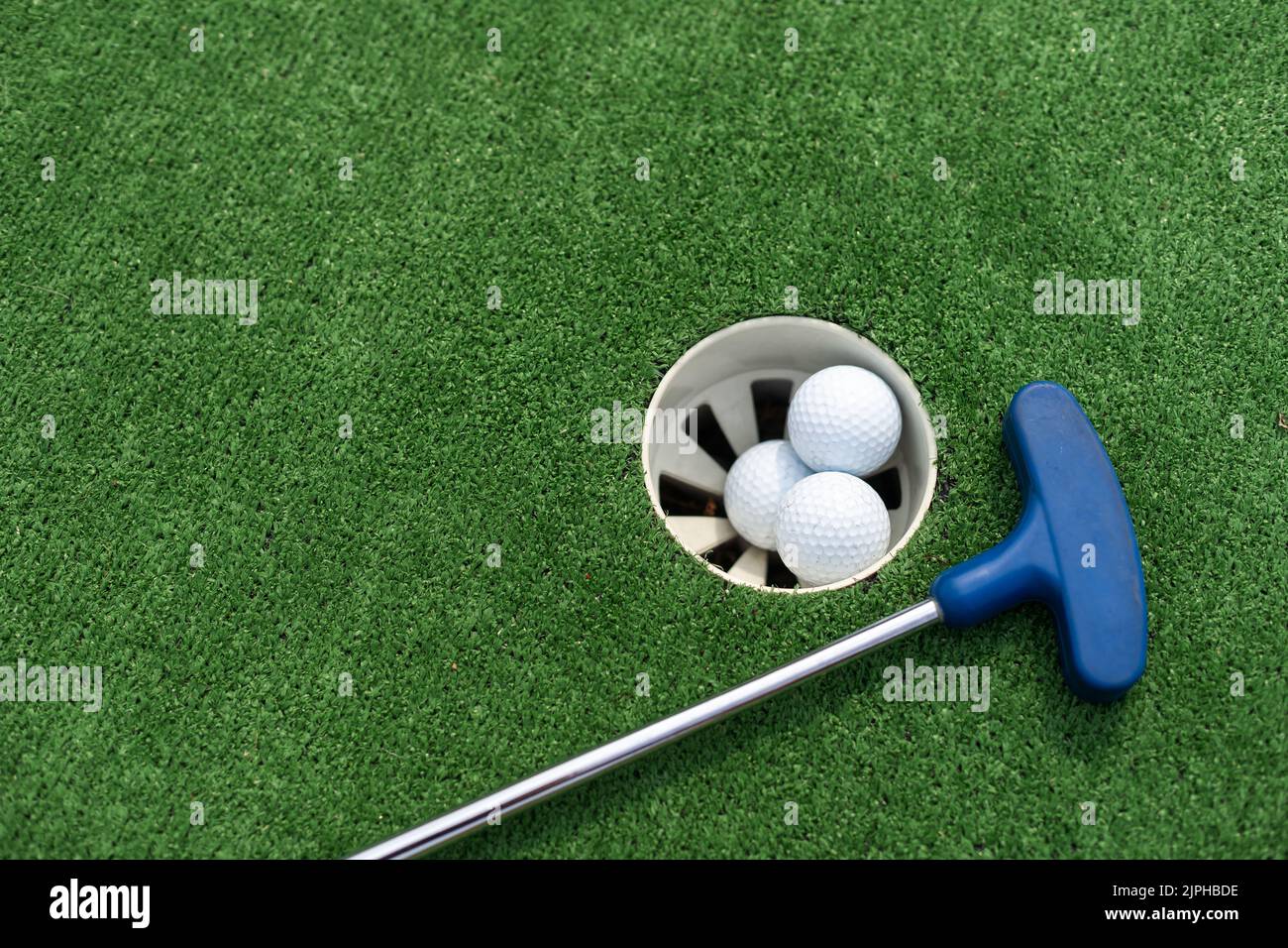Close-up of miniature golf hole with bat and ball Stock Photo - Alamy