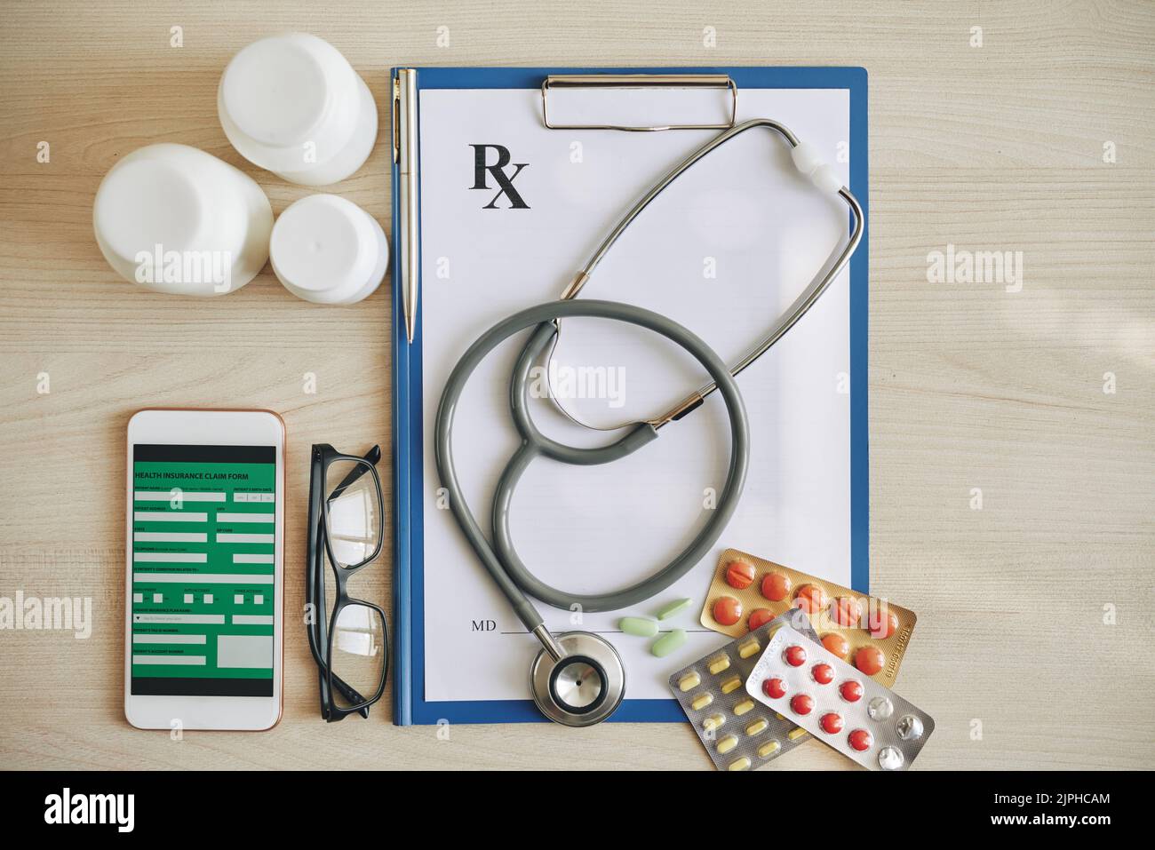 Medical insurance form, prescription document and tablets on desk of ...