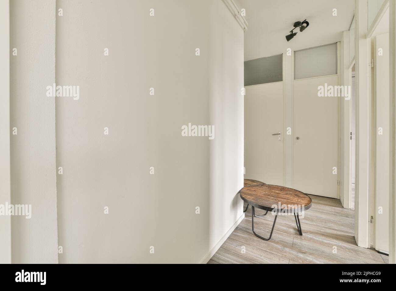 Perspective view of empty narrow hallway with white walls and wardrobe ...