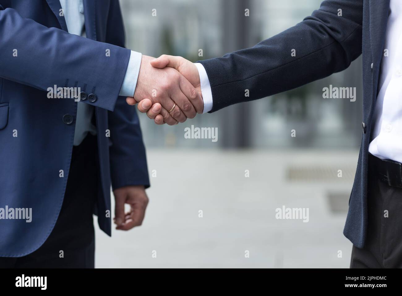 Close-up photo, two businessmen greet each other and shake hands ...
