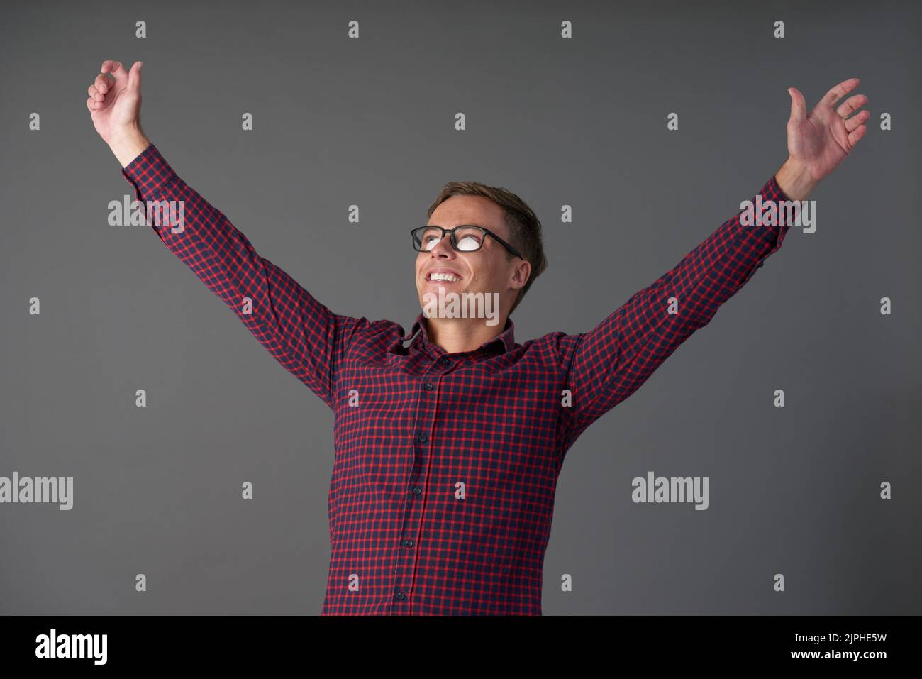 Happy excited young man in glasses rising his arms Stock Photo - Alamy