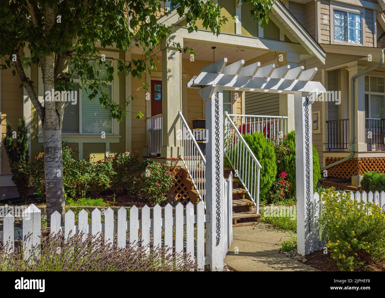 Entrance to a home through a beautiful garden with colorful flowers ...
