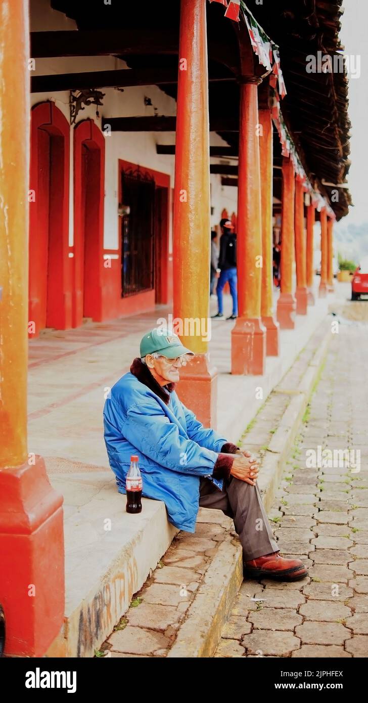 happy old man, sitting waiting, sitting on steps while drinking a cola ...