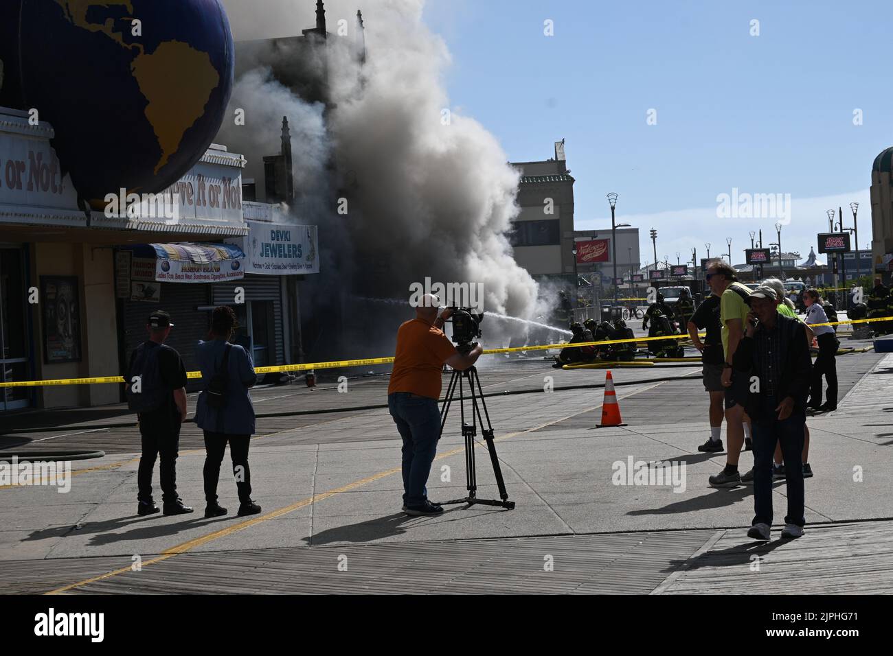 The crowd of people, firefighters, and policemen in the street during ...