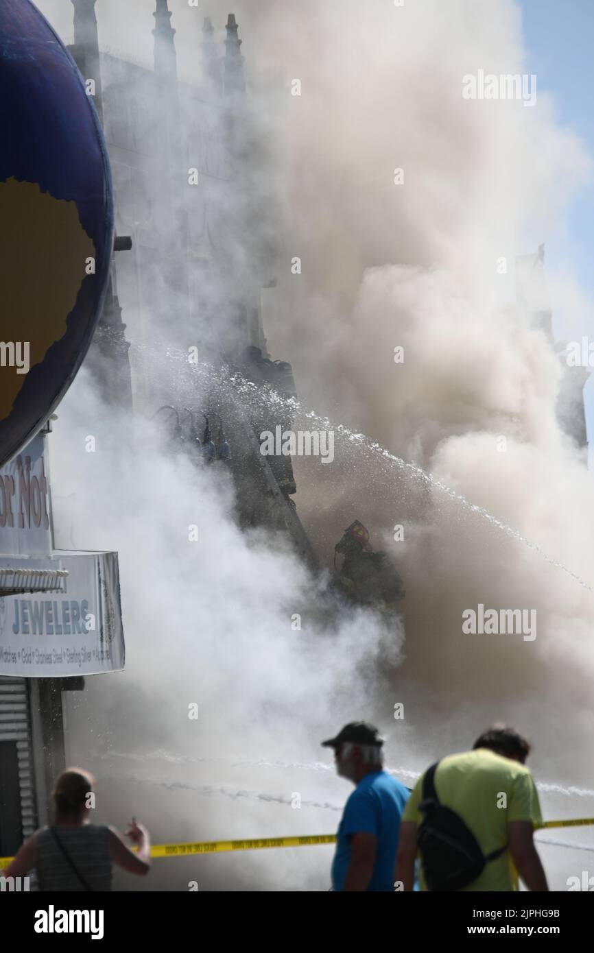 The crowd of people, firefighters, and policemen in the street during ...
