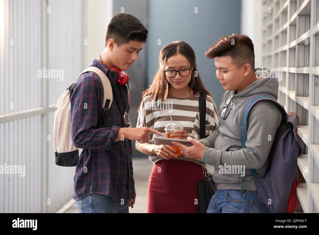Group of Asian students playing game on modern digital tablet and ...