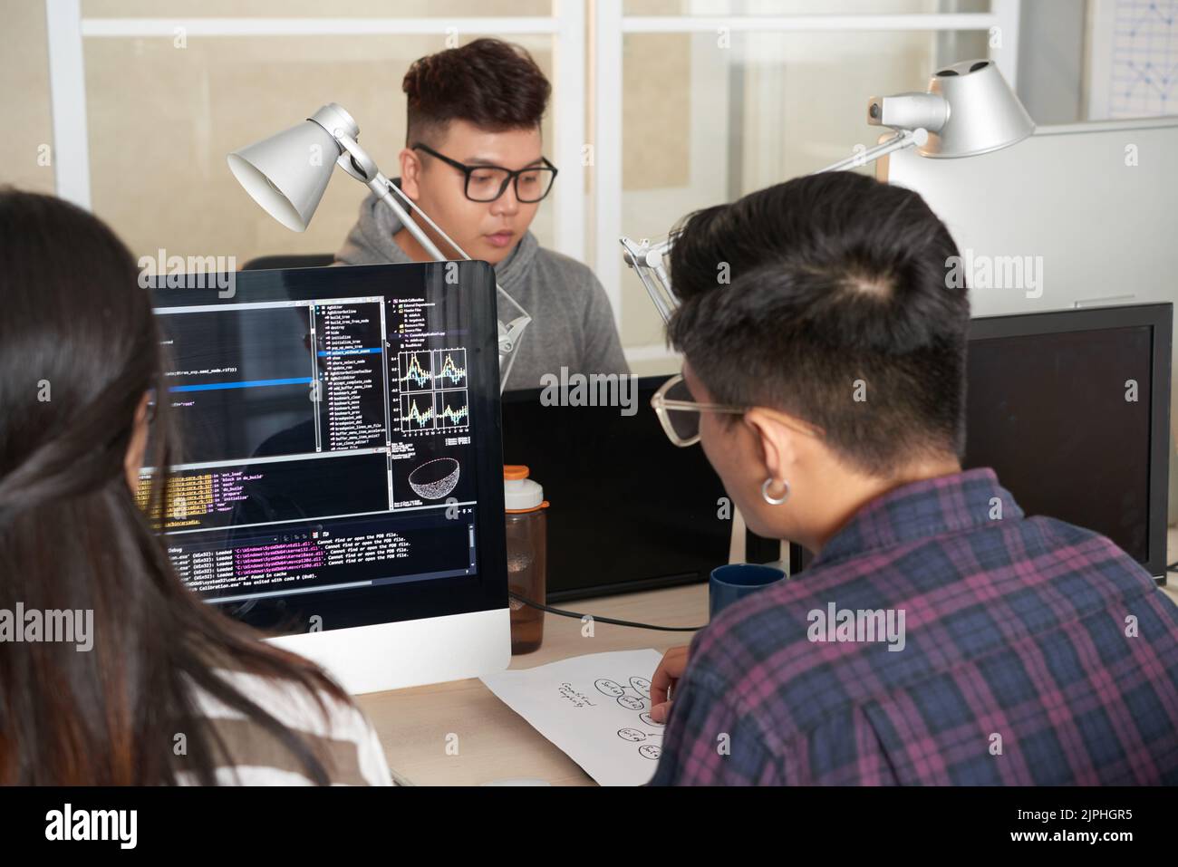 Back View Of Male And Female Programmers Working Together On Ambitious
