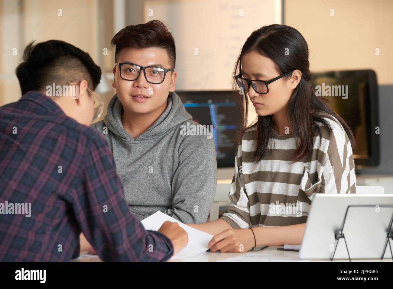 Group of talented young white collar workers gathered together at open ...