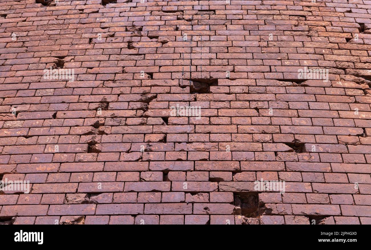 An old brick wall with various damages, the wall is old and made of ...