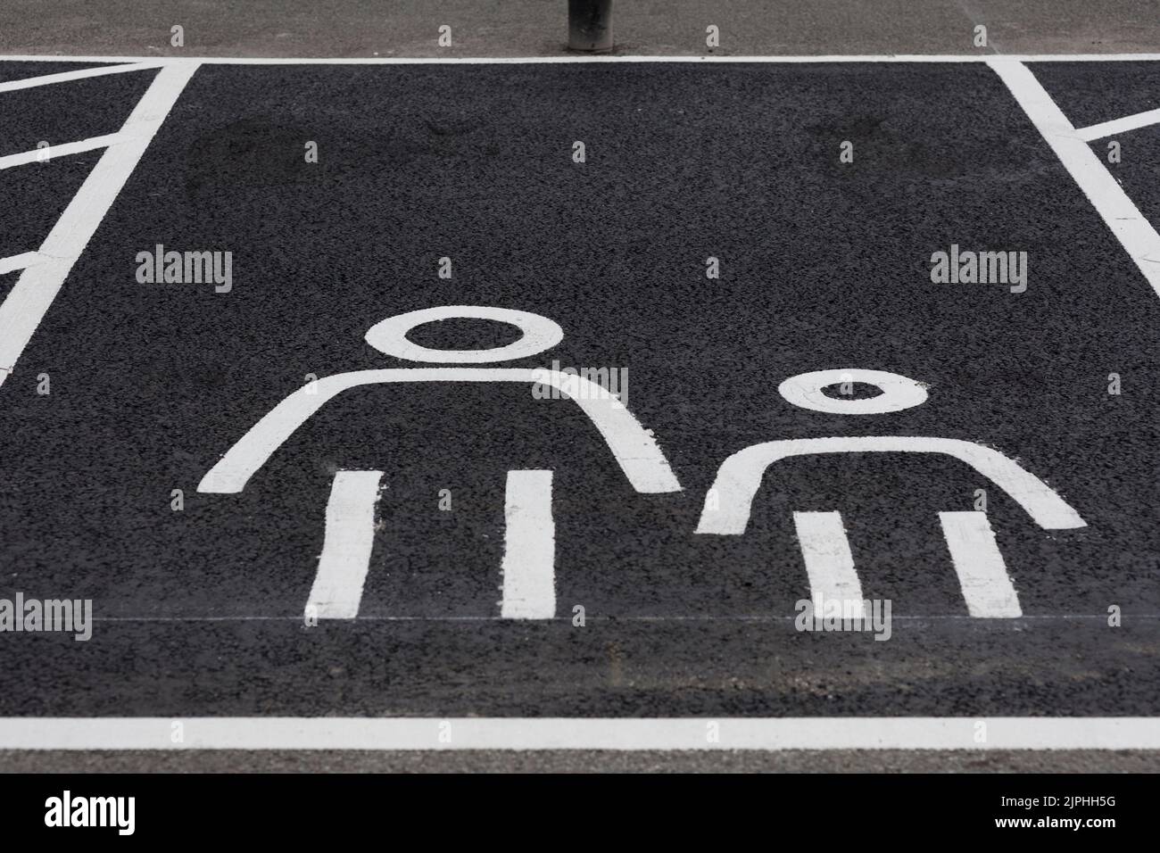 Family and children marking sign on tarmac Stock Photo - Alamy