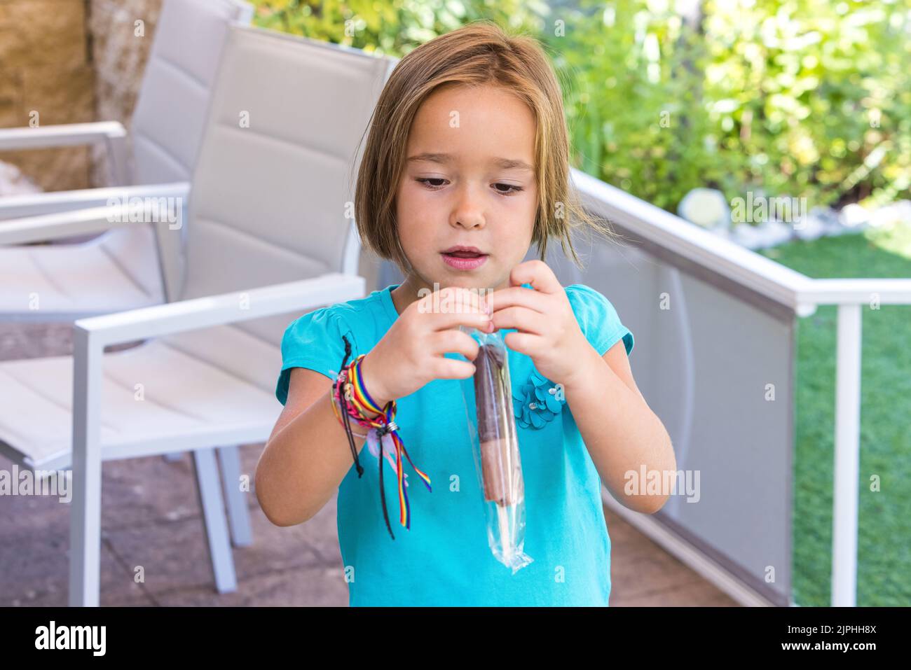 Girl wearing green t-shirt, holding a milk chocolate ice cream, in the ...