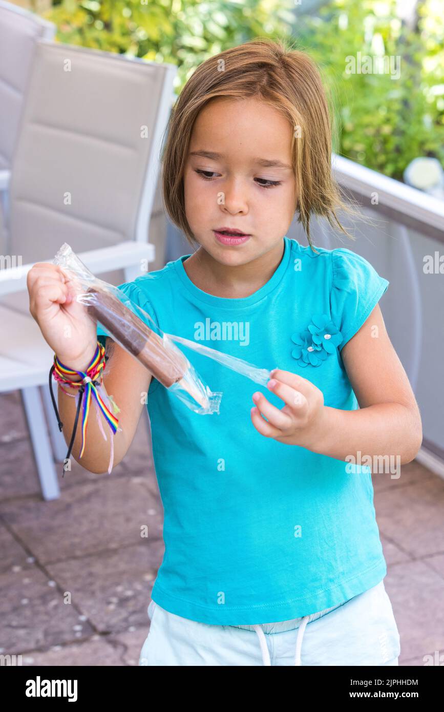 Girl wearing green t-shirt, holding a milk chocolate ice cream, in the ...