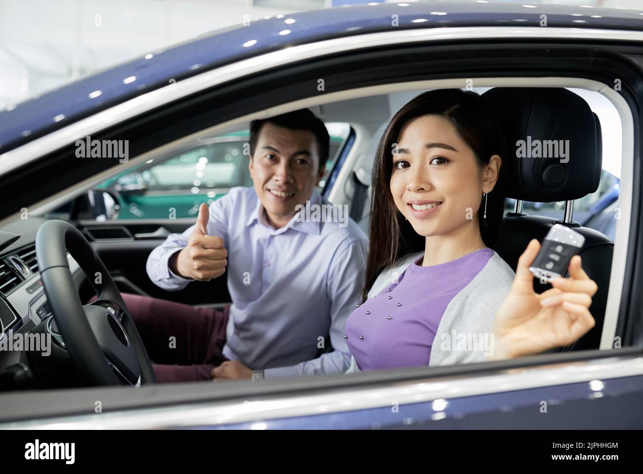 Happy Asian couple sitting in their new car Stock Photo - Alamy