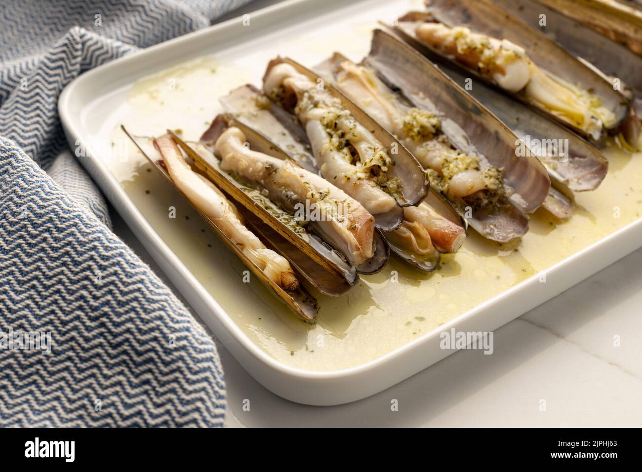 Coked Ensis Clams with garlic and herbs on plate. Typical dish of ...