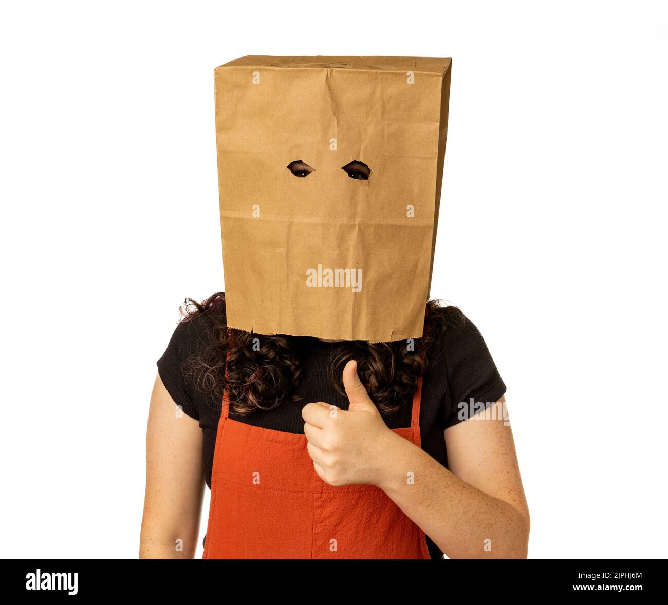 Young woman wearing paper bag over her head giving thumbs up with left ...