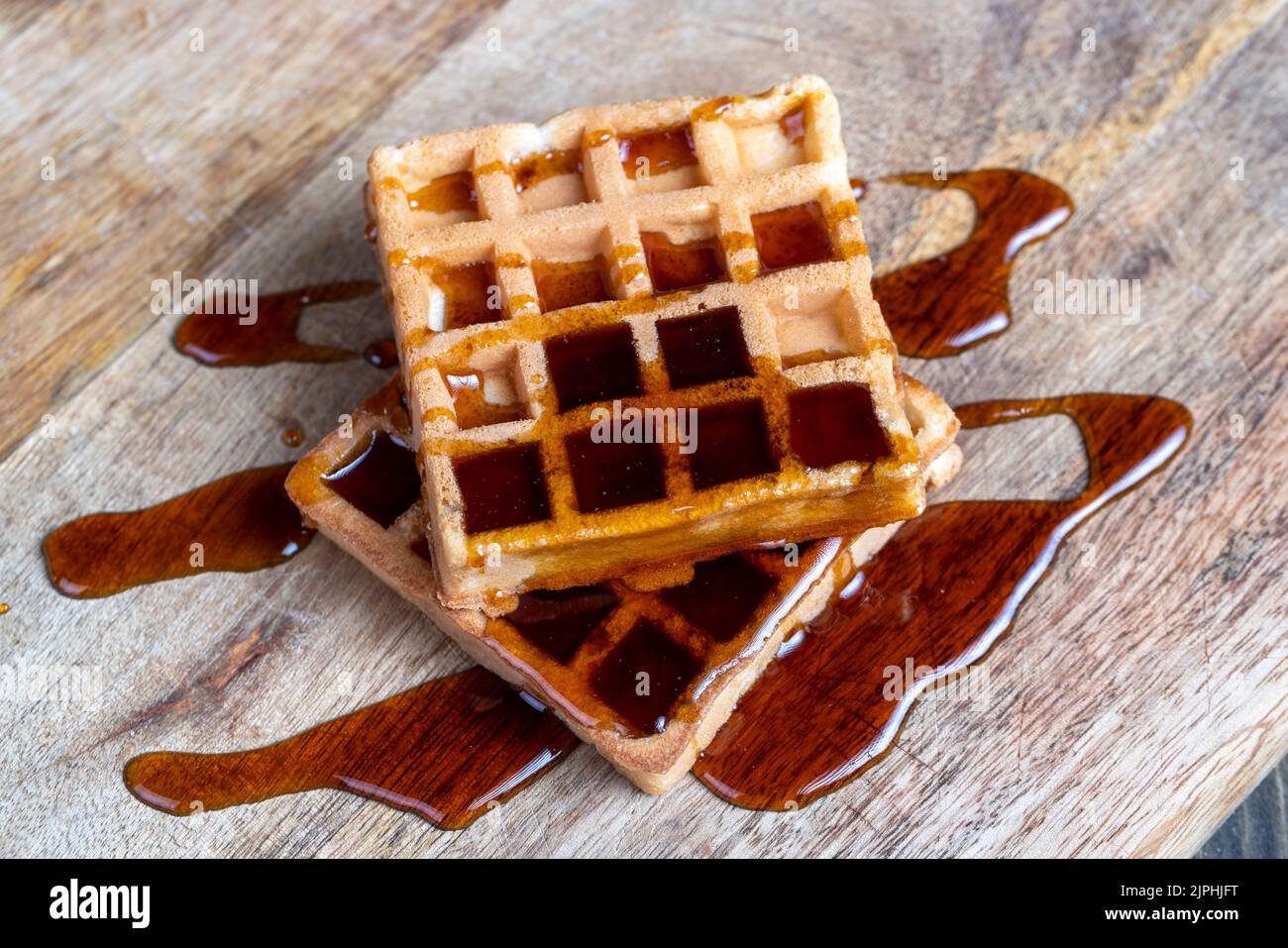 square sweet soft waffles in bee honey , a traditional European dessert ...
