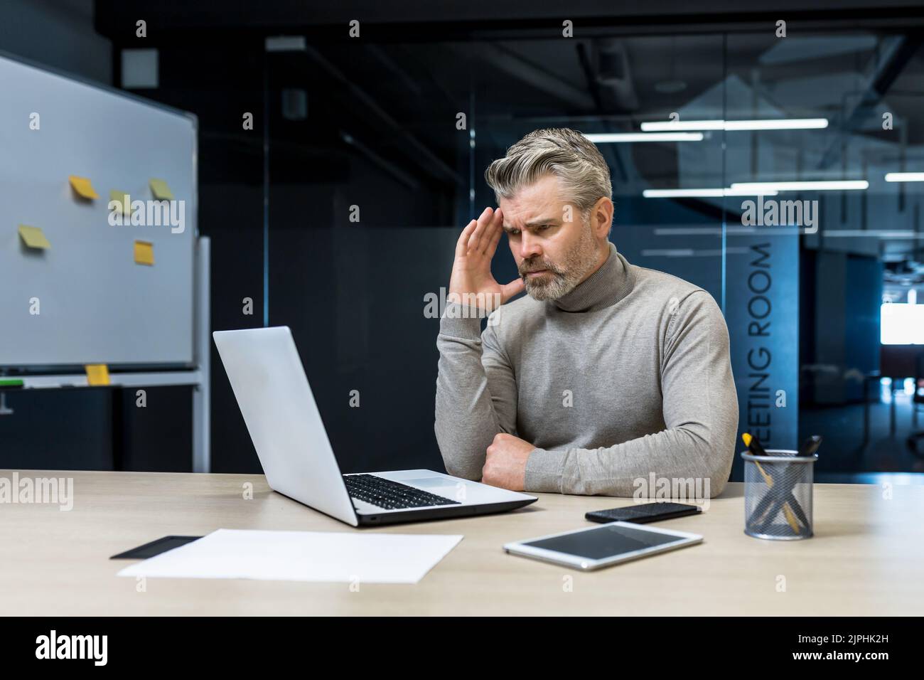 Senior experienced gray-haired investor working in modern office ...