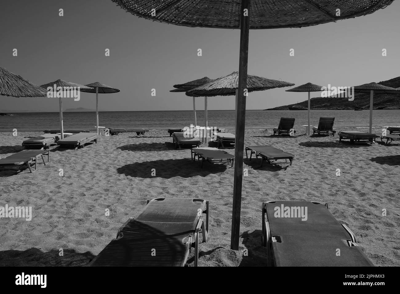 Empty sun beds and a sun umbrellas at the amazing beach of Manganari in ...
