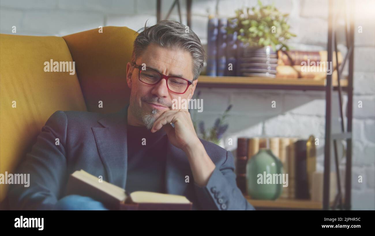 Smiling mature man home reading book hi-res stock photography and ...