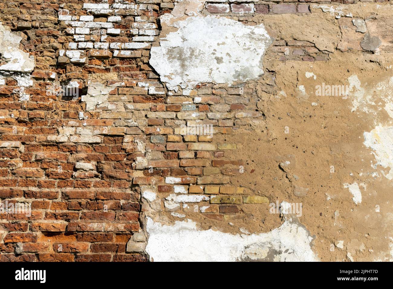 An old brick wall with various damages, the wall is old and made of ...