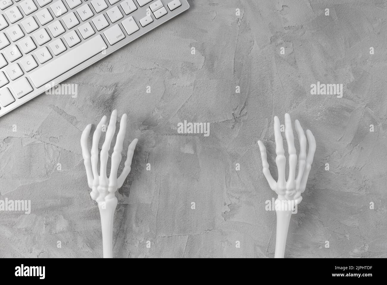 Halloween gray background with white skeleton hands and computer ...