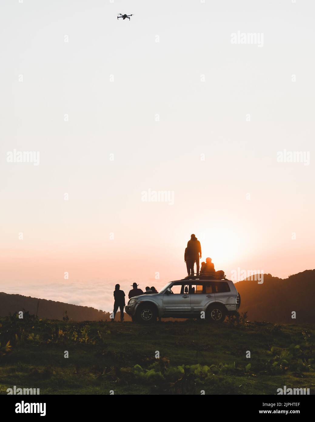 Group of travelers content creators stand by 4wd vehicle together ...