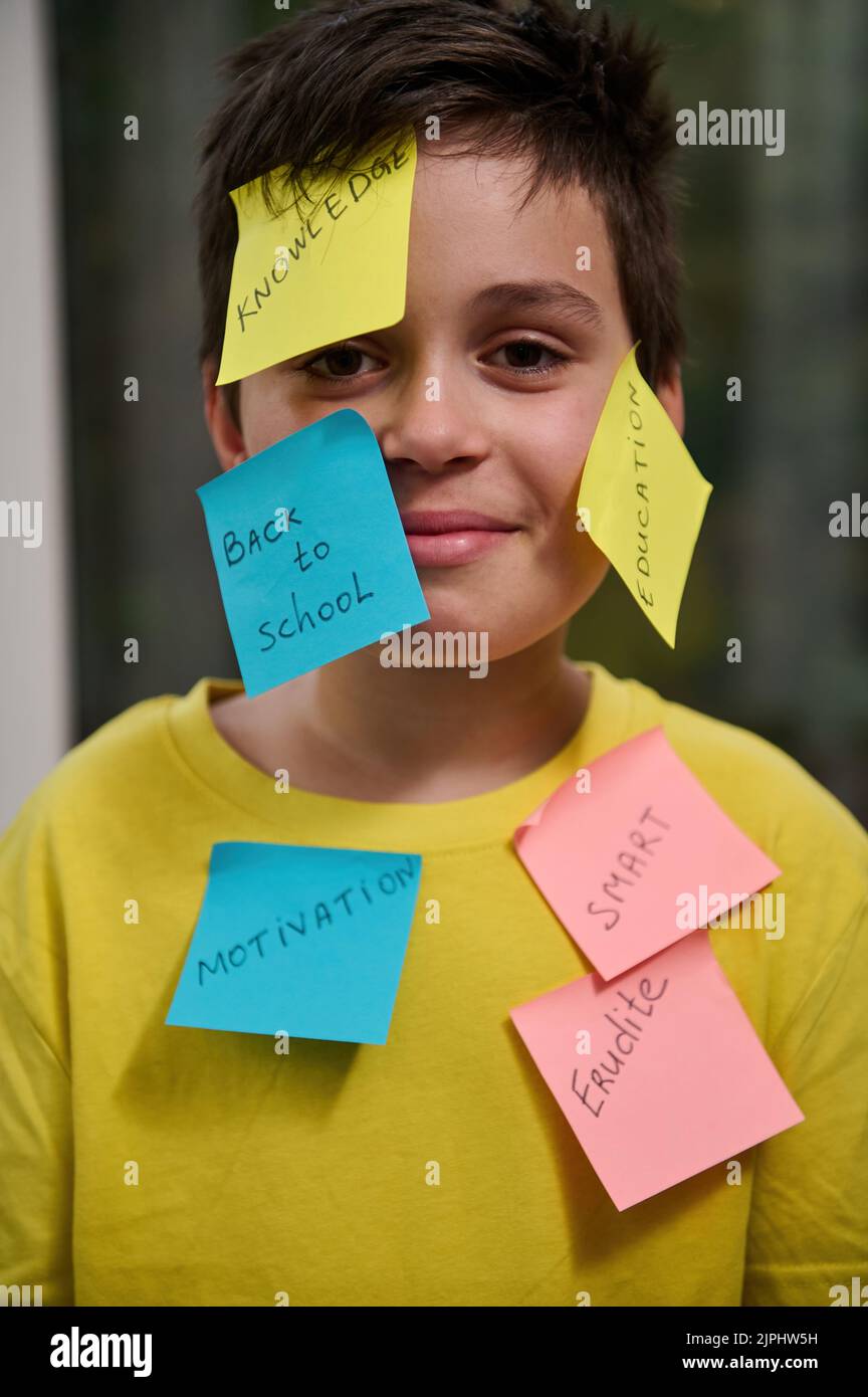 Multitasking pupil with glued paper with notes on face and t-shirt with ...