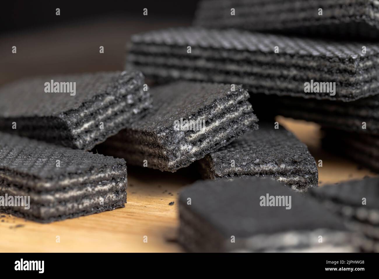 sweet dessert black waffles with creamy filling inside, laid out on a ...