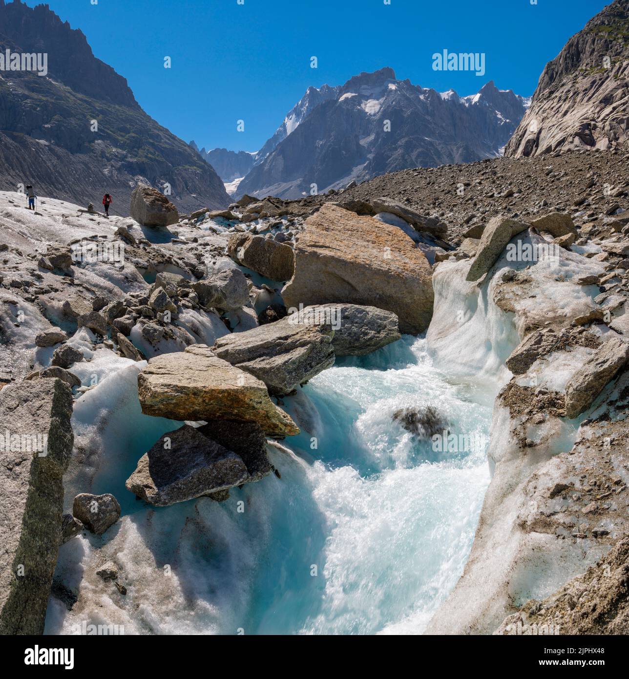 The glacial stream on the glacier Mer de Glace with the Garand Jorasses ...