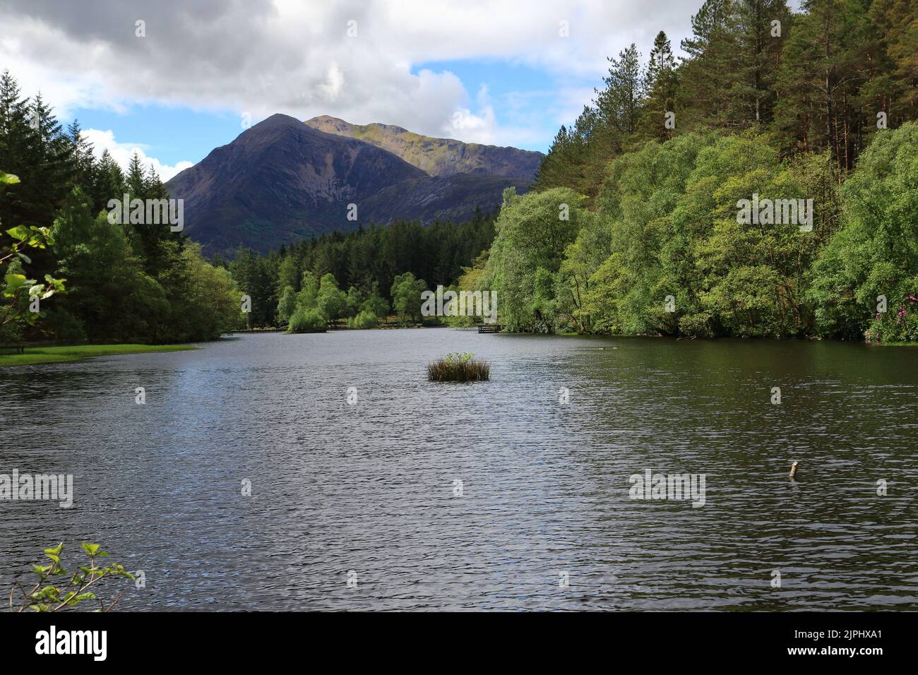 A peaceful loch surrounded by dramatic mountains hi-res stock ...