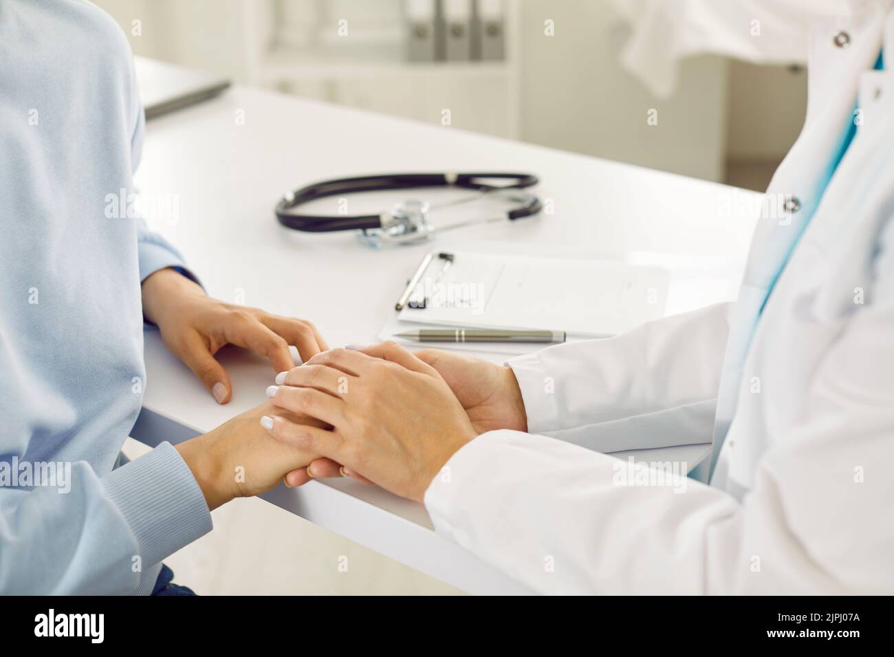 Doctor comforting young woman, reassuring her, showing support and ...