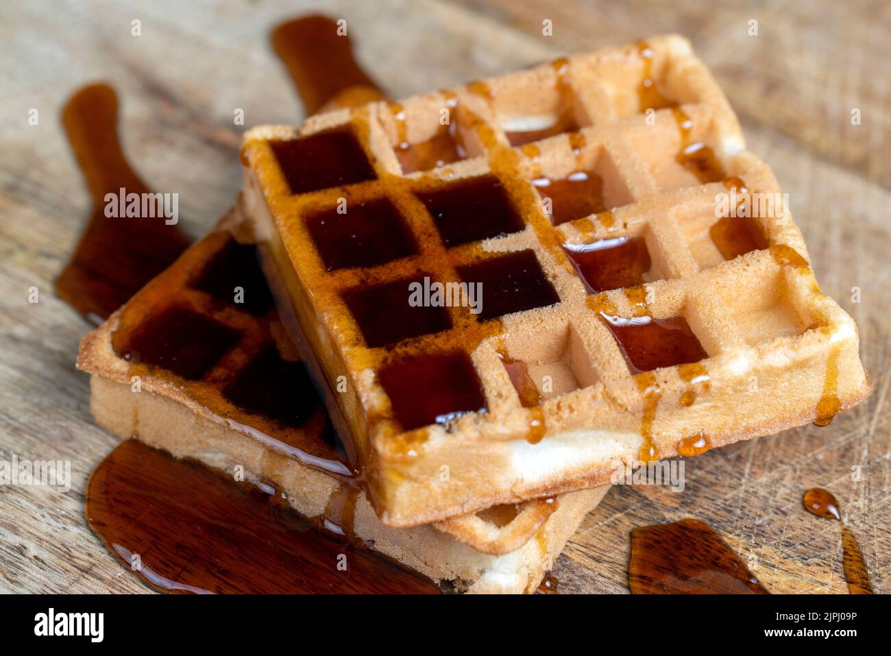 square sweet soft waffles in bee honey , a traditional European dessert ...