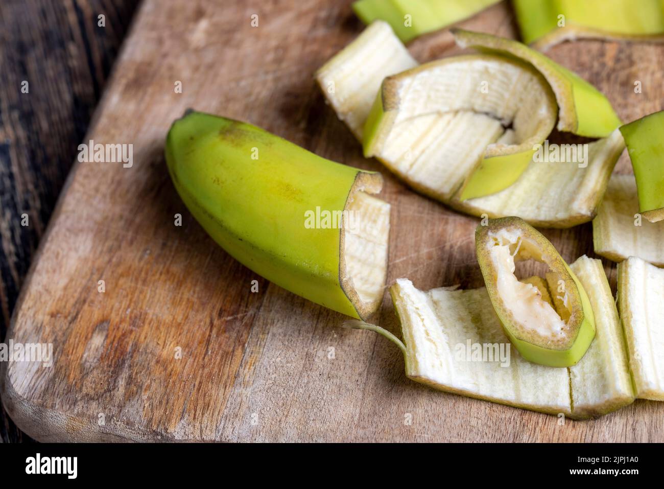 unripe green banana cut into pieces, banana with green peel on the ...