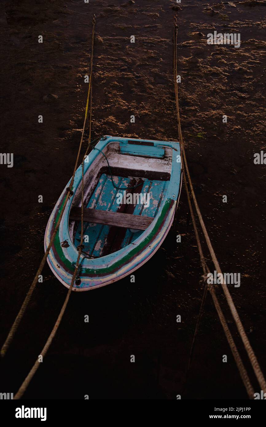 Boat tied with rope during low tide at night Stock Photo - Alamy