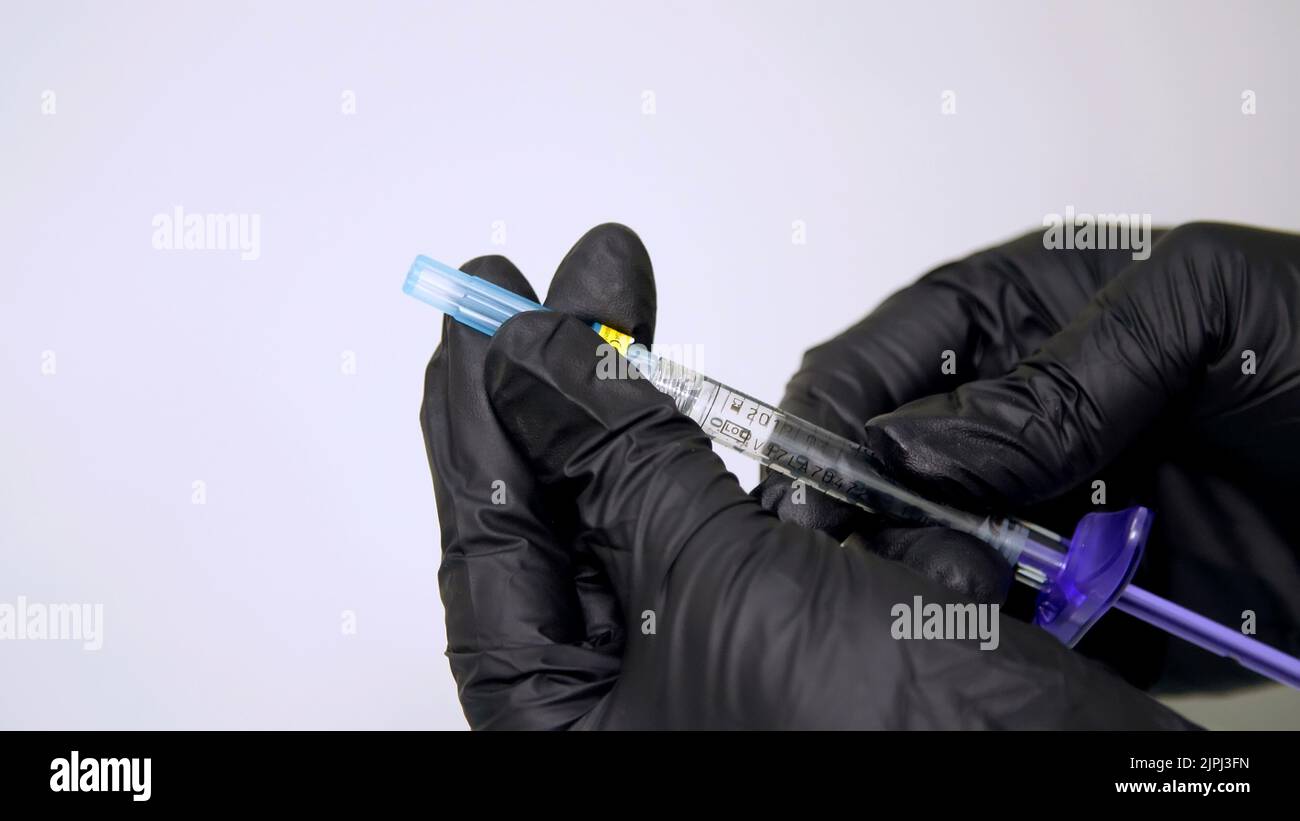 close-up, a sterile syringe with hyaluronic acid in the hands of a ...