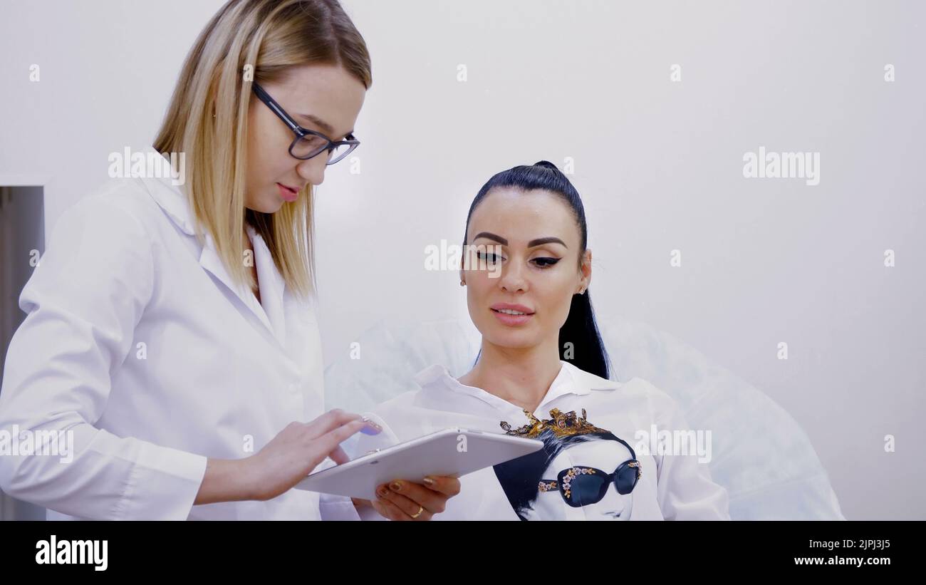 cosmetology room, two young beautiful women, a doctor and a patient ...