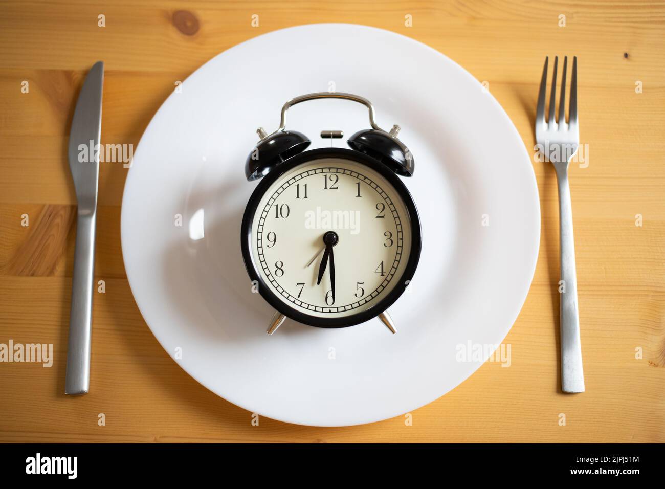 intermittent fasting concept alarm clock on kitchen table Stock Photo ...