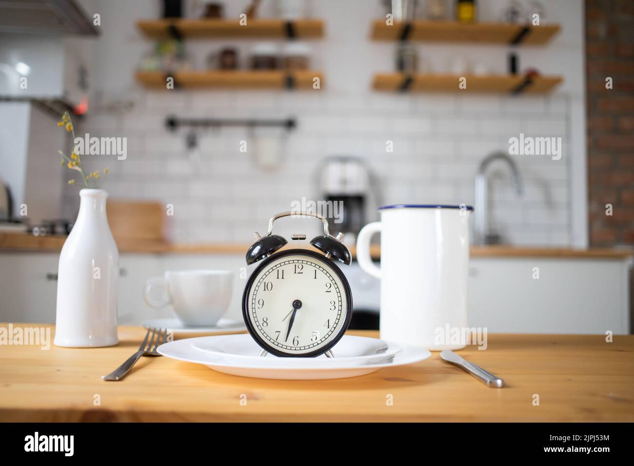 intermittent fasting concept alarm clock on kitchen table Stock Photo ...