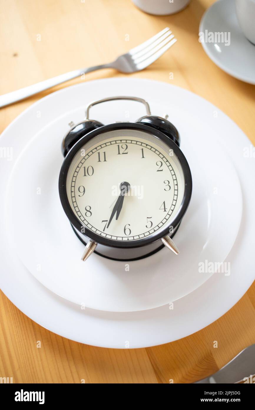 intermittent fasting concept alarm clock on kitchen table Stock Photo ...